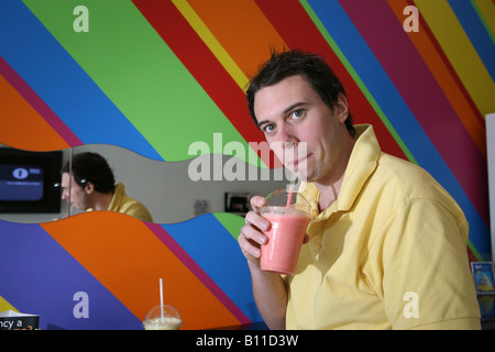 a happy male customer drinking a fruit smoothie in a smoothie bar Stock ...