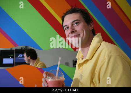a happy male customer drinking a fruit smoothie in a smoothie bar Stock ...