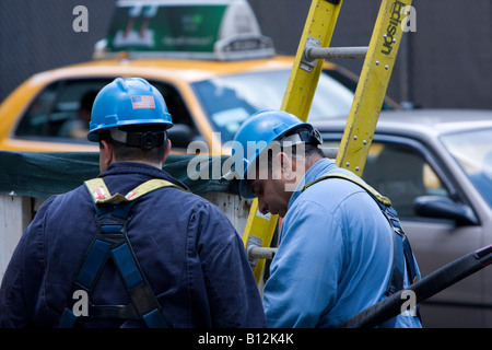 Employee of Con Edison power company in NYC uses a sensor to measure ...