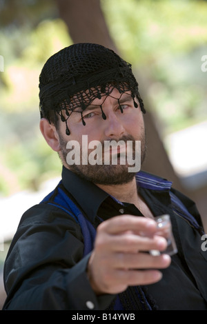 One Cretan man holding shot of Cretan traditional tsikoudia spirit ...