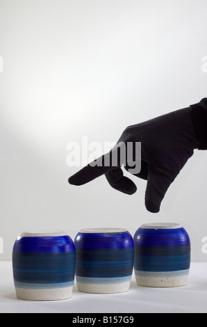 Trick with three cups Stock Photo - Alamy