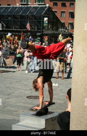 A street performer doing acrobatics in front of a crowd in the city ...