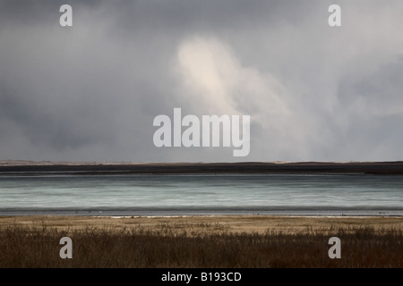 Storm clouds over frozen slough in early spring Stock Photo - Alamy