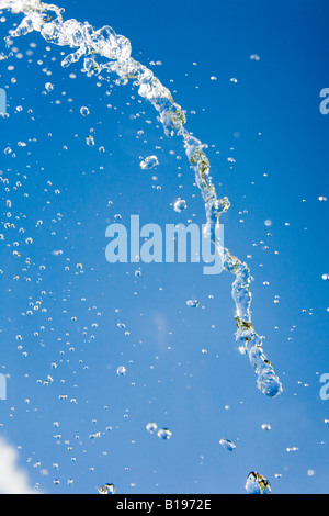 Jet of water frozen against a bright blue sky Stock Photo - Alamy