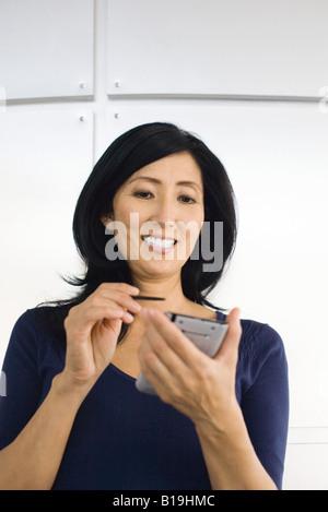 Asian woman smiling with electronic organizer Stock Photo - Alamy