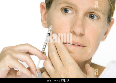 Close up of cosmetic botox injection in female lips. Front view of ...
