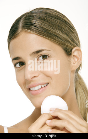 Pretty young woman uses cosmetics for looking young and beautiful, has ...