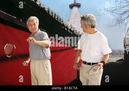 two oriental senior adults playing badminton Stock Photo - Alamy