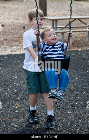 Brothers playing on the playground equipment at the park Stock Photo ...