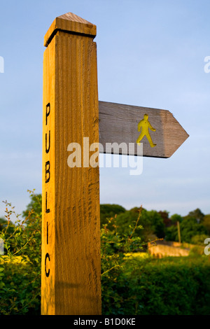Wooden public footpath signpost sign and dry stone wall overlooking ...