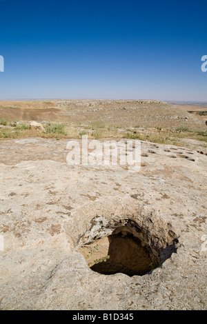 View of holes and pit in bedrock at The Neolithic site of Gobekli Tepe ...