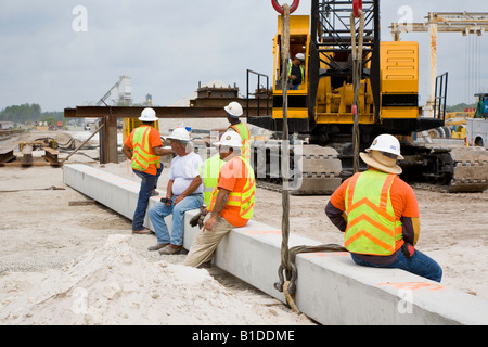 Construction crew rigging prestressed precast concrete piling to be ...
