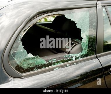 Smashed rear quarter window of black Jaguar car parked on a York street ...