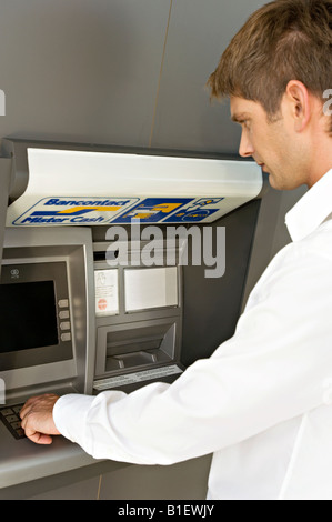 Side profile of a businessman using an ATM machine Stock Photo - Alamy