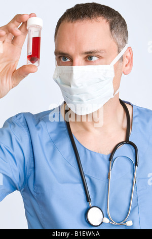 Serious male doctor looking at blood sample Stock Photo - Alamy