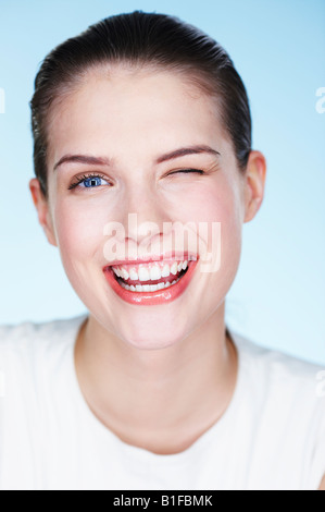 Image of smiling beautiful woman winking and holding fingers crossed ...