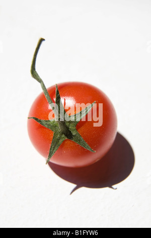 Single ripe star fruit with green and yellow skin resting on weathered ...