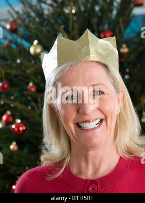 Mature woman in party hat with Birthday gift on orange background Stock ...