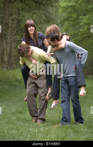 Two couples playing piggyback Stock Photo - Alamy