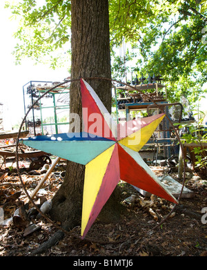 Colorful painted star made of metal leaning against tree Stock Photo ...