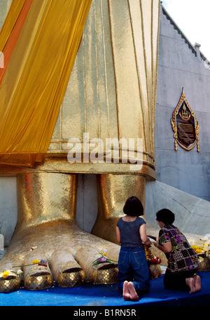 A woman praying at the feet of the giant Buddha statue in Wat ...