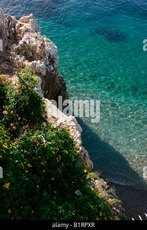 Elevated view of a rocky shoreline and crystal-clear coastal water ...