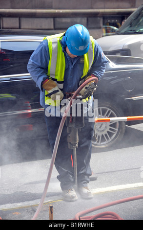 Construction workers are using jack hammer tools to destroy the street ...