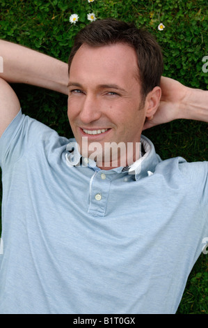 31-year-old man lying on the grass, smiling Stock Photo - Alamy
