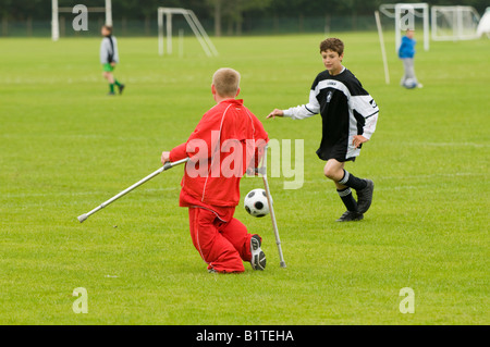 A young disabled boy playing football Stock Photo - Alamy