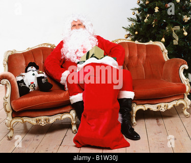 Santa taking a rest on sofa Stock Photo - Alamy