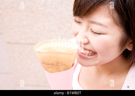 Japanese young woman eating crepe Stock Photo - Alamy