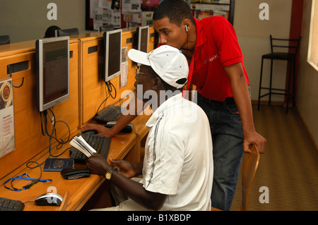 Qualified staff of the Internetcafé Busyinternet assists a client at ...