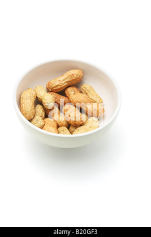 Unshelled peanuts in a bowl isolated on the white background. File ...