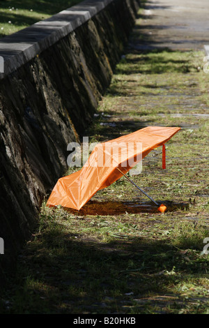 old orange umbrella left on pavement in town Stock Photo - Alamy
