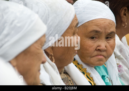 An elderly Kazakh woman wearing a traditional white head covering known ...