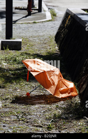 old orange umbrella left on pavement in town Stock Photo - Alamy