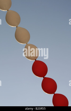 long line of red white balloons in blue sky Stock Photo - Alamy