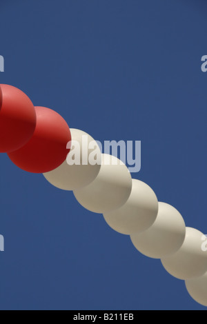 long line of red white balloons in blue sky Stock Photo - Alamy