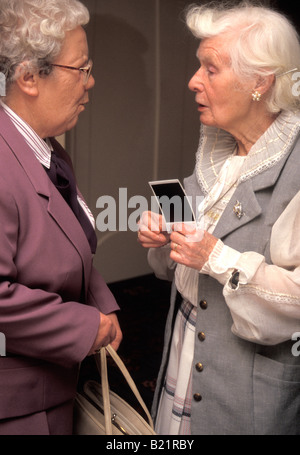 Two elderly women talking gossip Stock Photo - Alamy