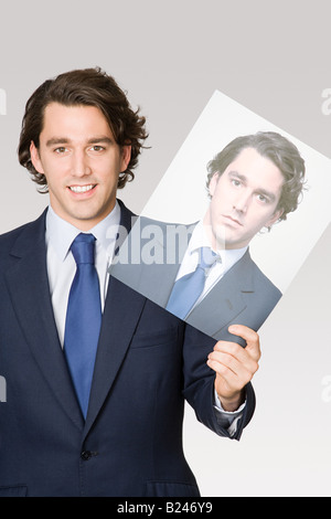 Portrait of a man holding a photograph of himself Stock Photo - Alamy