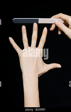 Cropped view of woman filing nails isolated on beige Stock Photo - Alamy