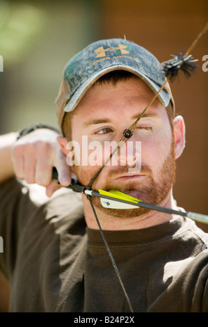 Bow and Arrow hunter practicing on a target in the backyard using a ...