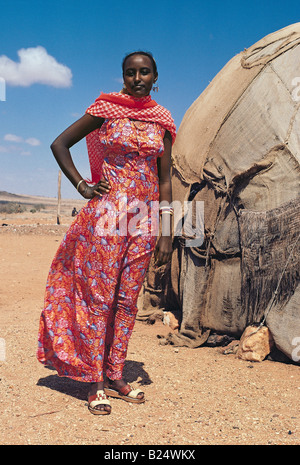 A young woman in a colorful patterned rash guard kneels on a ...