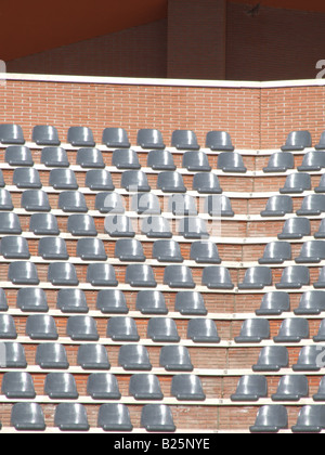 Folded blue and grey grandstand seats at the city stadium. Glass ...