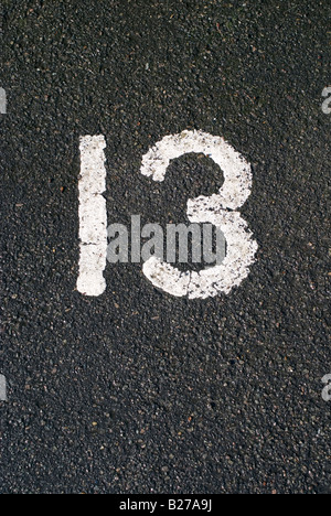 Painted number 13 on tarmac car park / parking lot space. Bad luck and ...