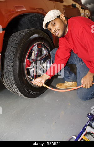 Man using air hose to pump up tire Stock Photo - Alamy
