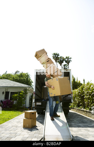 Young man balancing stack of boxes on moving truck ramp Stock Photo - Alamy