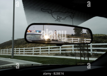 Traffic police through the rear view mirror of a car that they have ...
