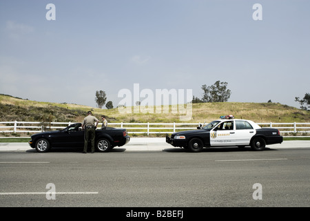 Two police officers approach a suspect Ferrari at DUI checkpoint Stock ...