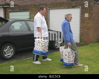 man helping elderly woman carry in bag for life reusable ...